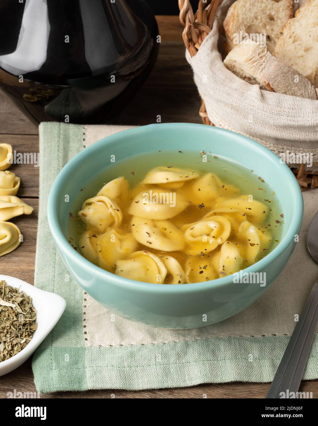 Cappelletti or tortellini brodo soup in a bowl with bread slices and ...