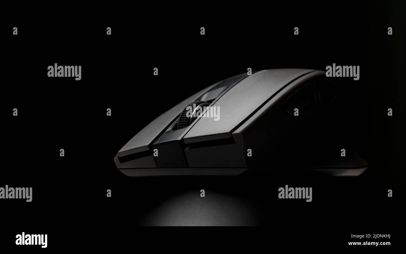 Black computer mouse on a black background.Mouse for PC filmed on a ...