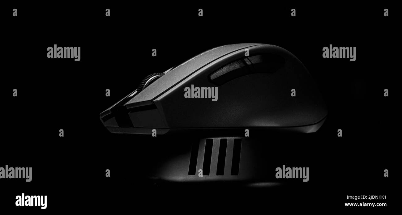 Black computer mouse on a black background.Mouse for PC filmed on a ...