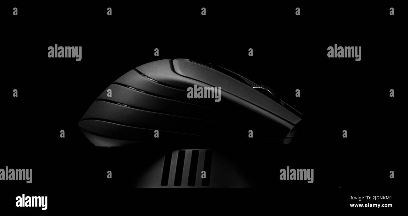 Black computer mouse on a black background.Mouse for PC filmed on a ...