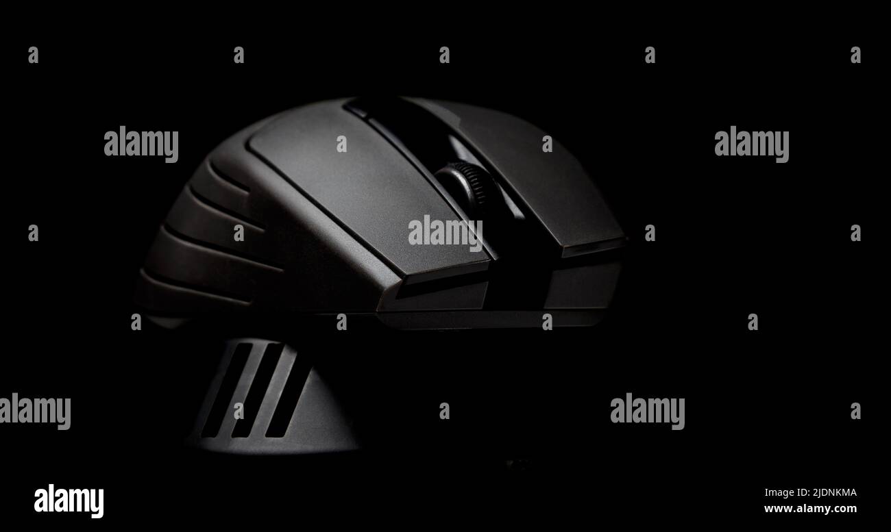 Black computer mouse on a black background.Mouse for PC filmed on a ...