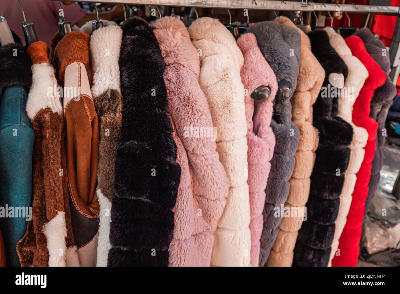 fur coats with synthetic fur on a hanger on the market Stock Photo - Alamy