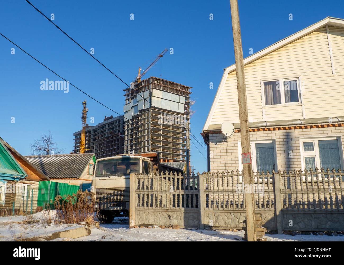 high-rise construction. Urbanization. Old small houses against the ...