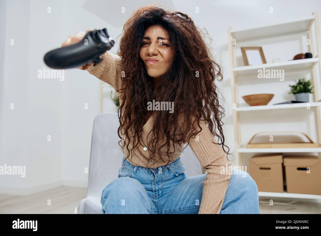 Irritated angry pretty tanned curly Latin lady lose game throw joystick ...