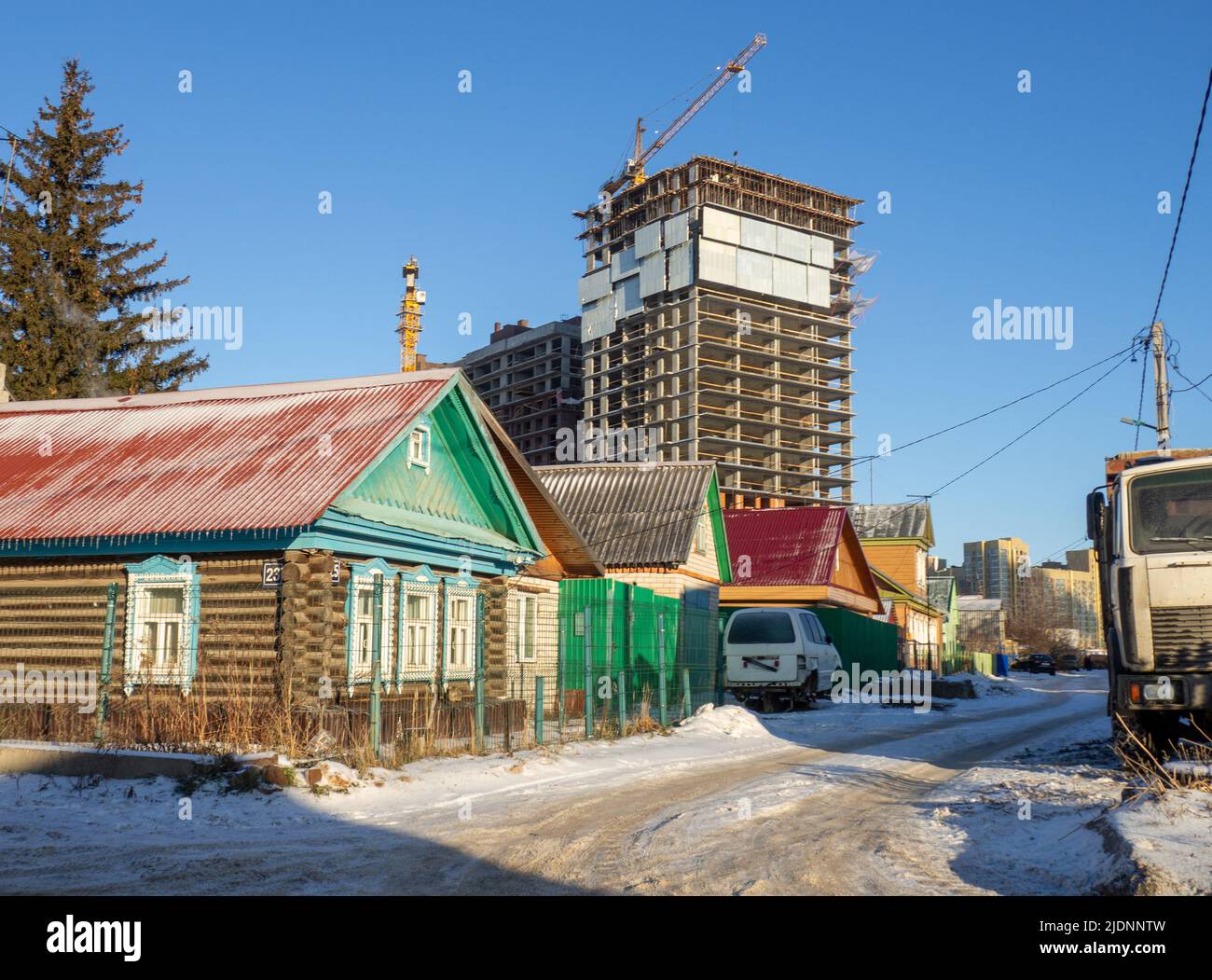 high-rise construction. Urbanization. Old small houses against the ...