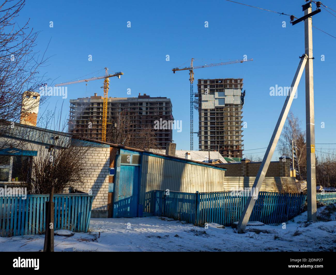 high-rise construction. Urbanization. Old small houses against the ...