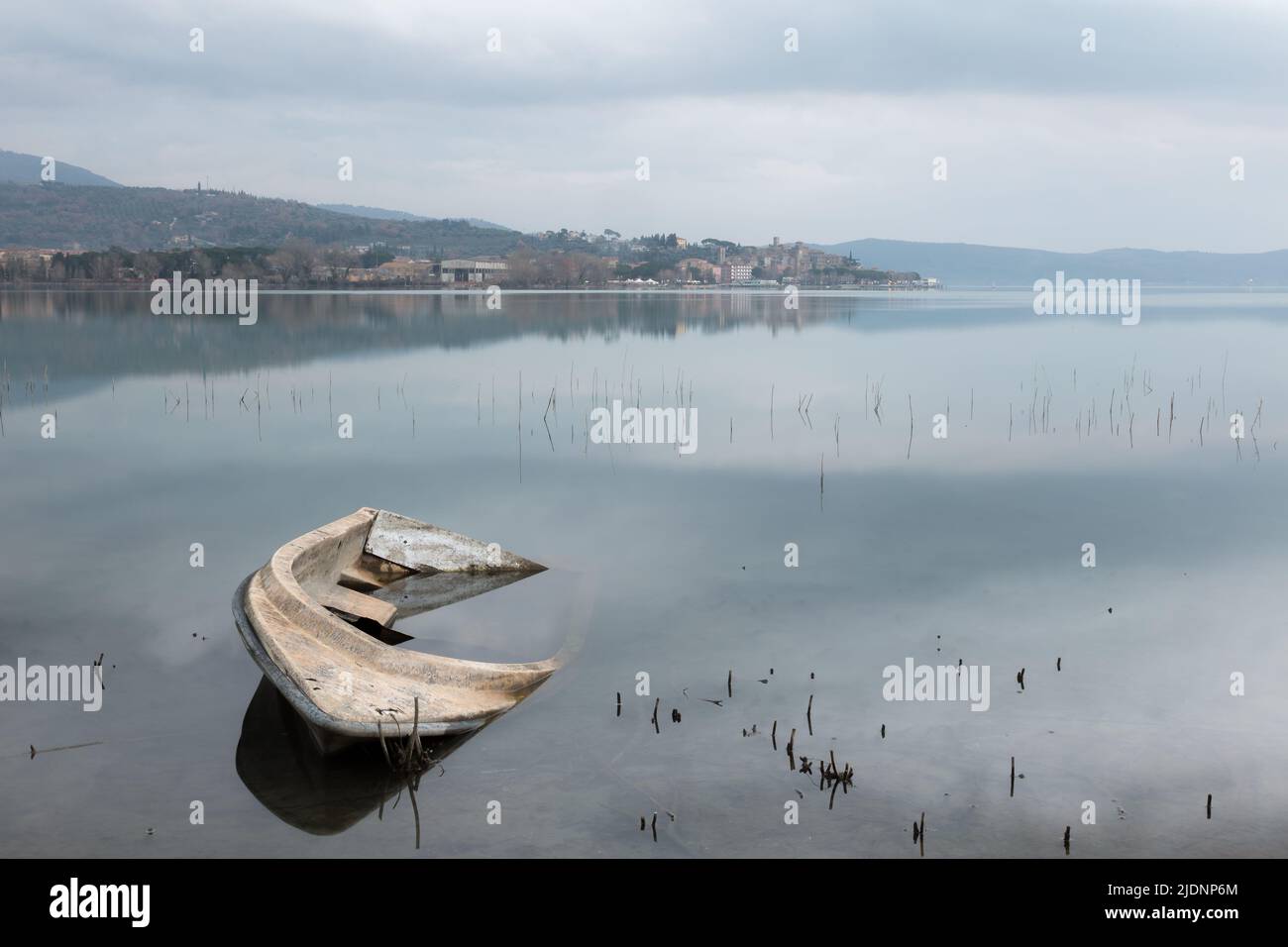 A sinking little boat on Trasimeno lake, Umbria, with Passignano town ...