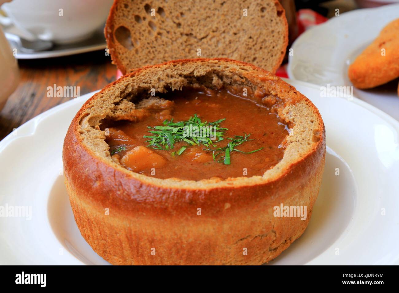 Original dish - goulash soup in bread pot, plate in restaurant, cafe ...