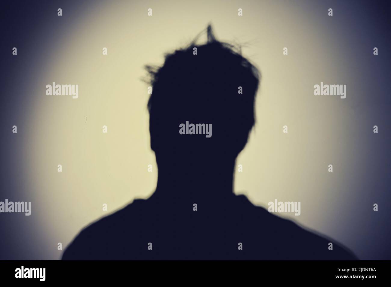 Shadow of a man from the night light of a flashlight on a white wall ...