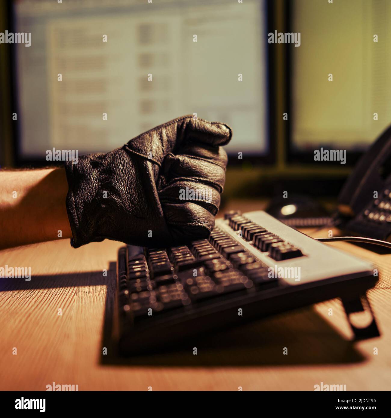 Angry man hacker in black gloves on his hands working on a computer ...