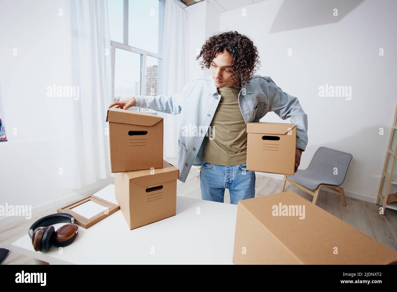 handsome guy unpacking things from boxes in the room Lifestyle Stock ...