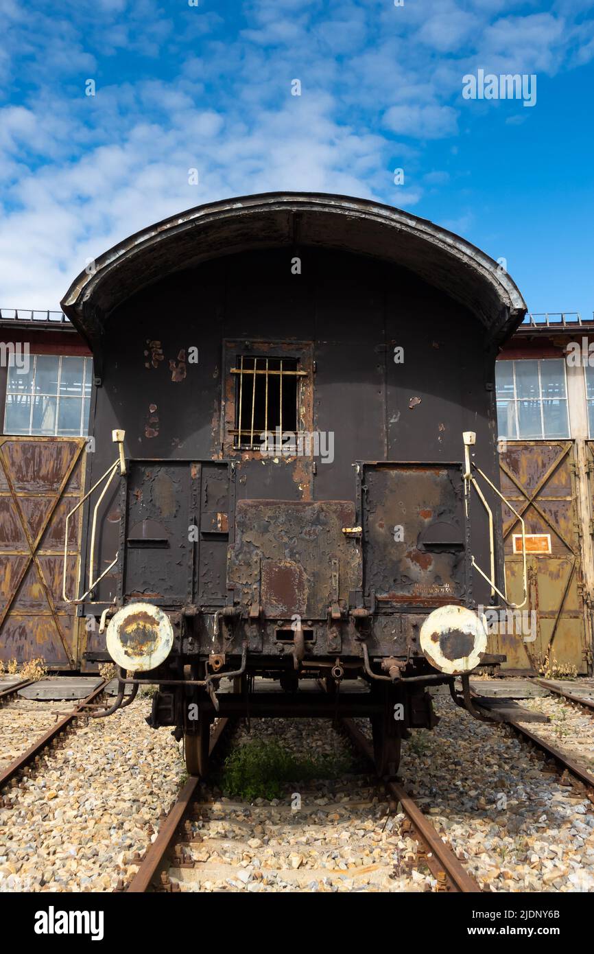 Old cargo cars standing outside of historic locomotive shed. The shot ...