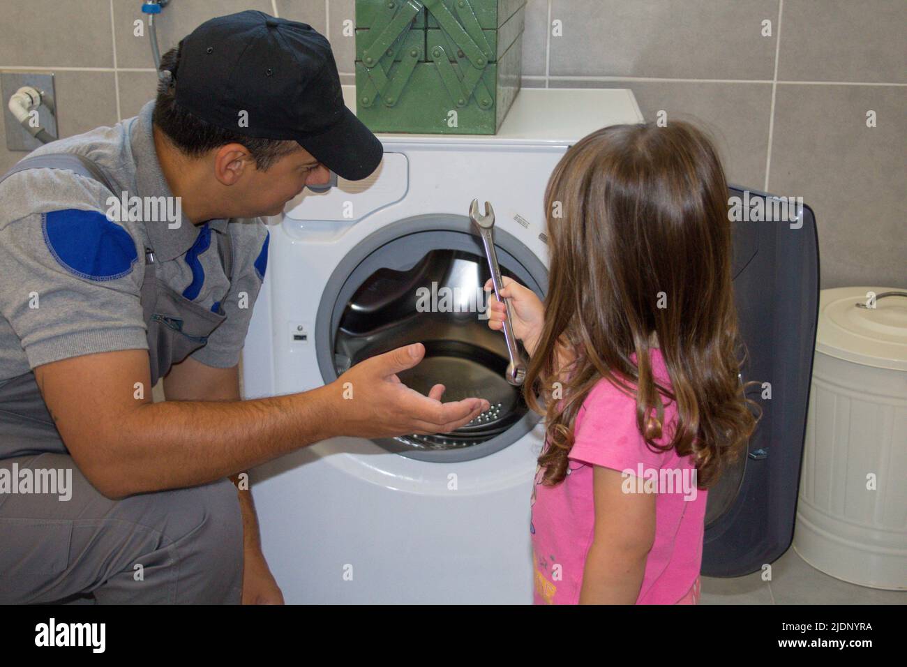 Picture of a handyman dad repairing a broken washing machine with his ...