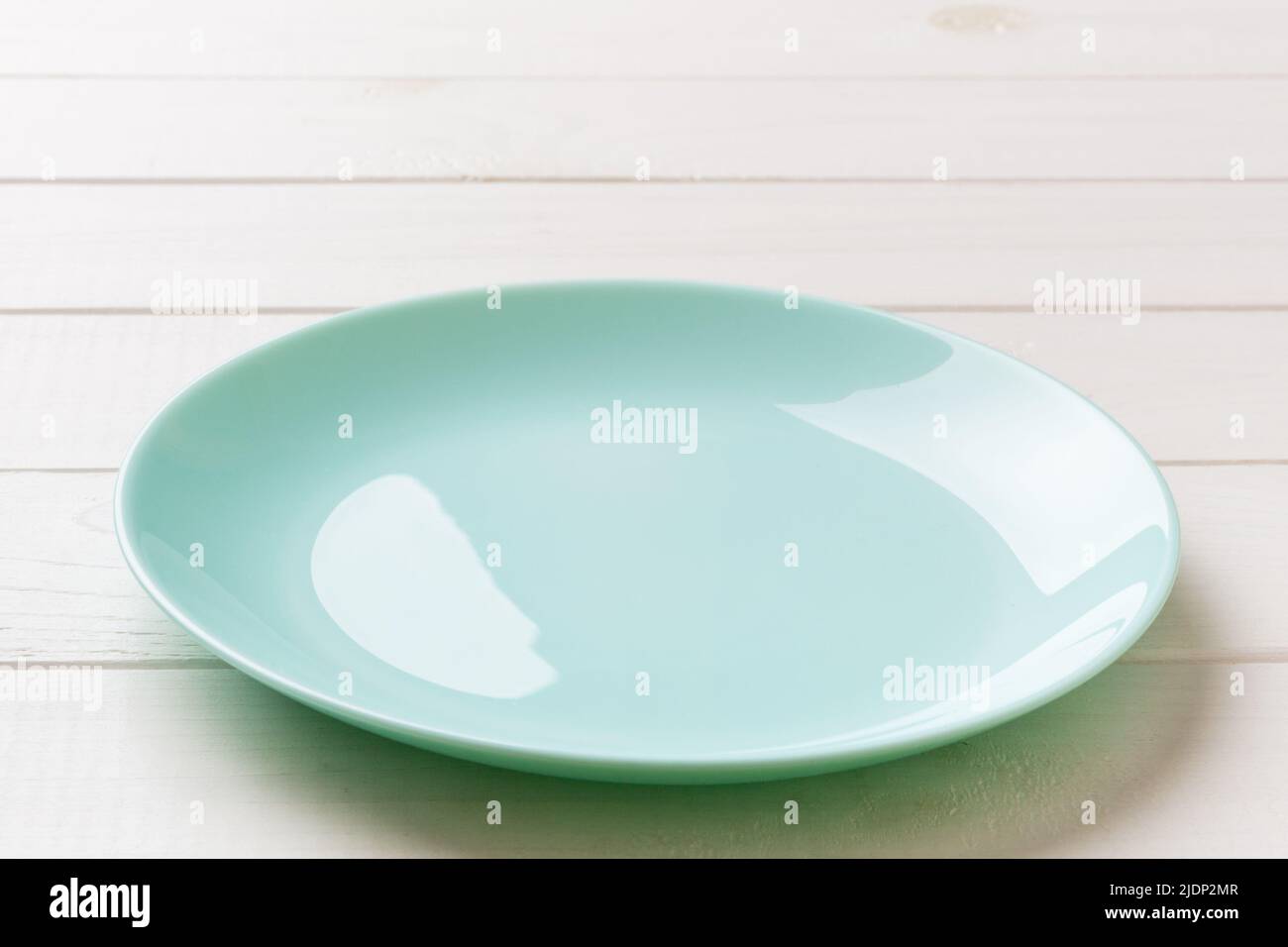 Perspective view of empty blue plate on wooden background. Empty space ...