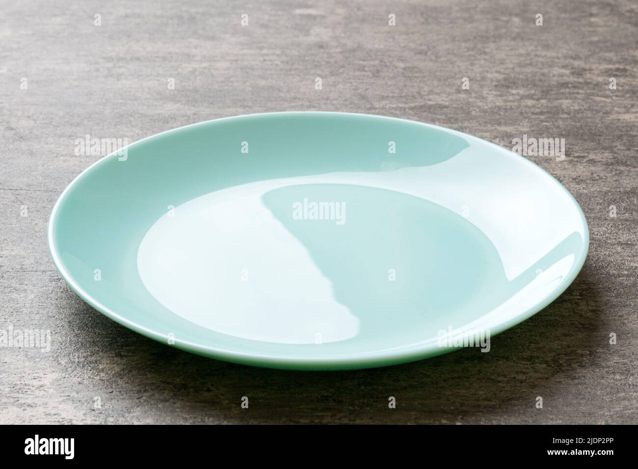 Perspective view of empty blue plate on cement background. Empty space ...