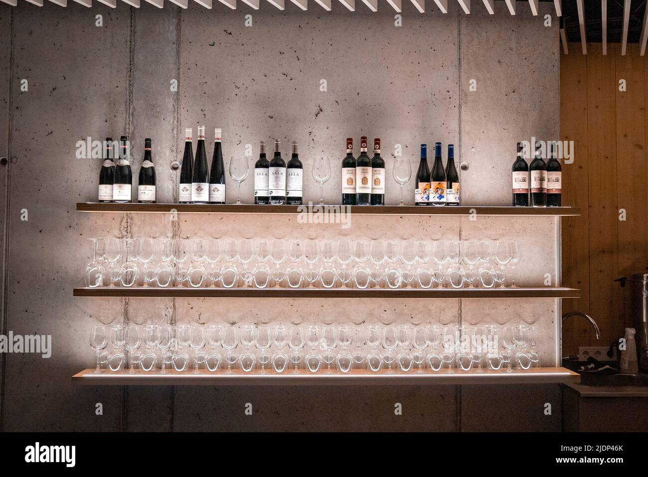 Various alcoholic bottles and wineglasses displayed on shelves at hotel ...
