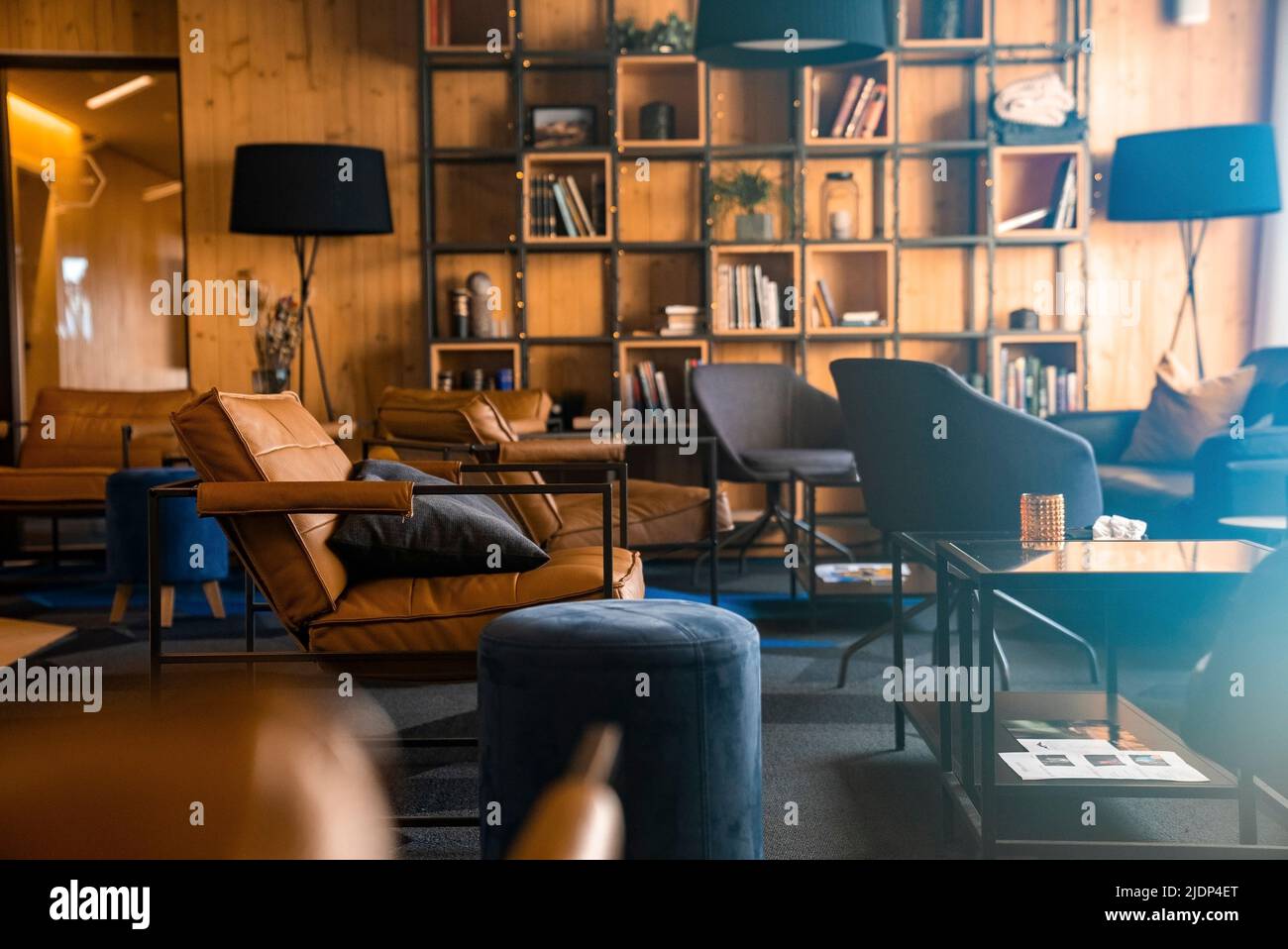 Chairs and table arranged against bookshelf in beautiful luxurious ...