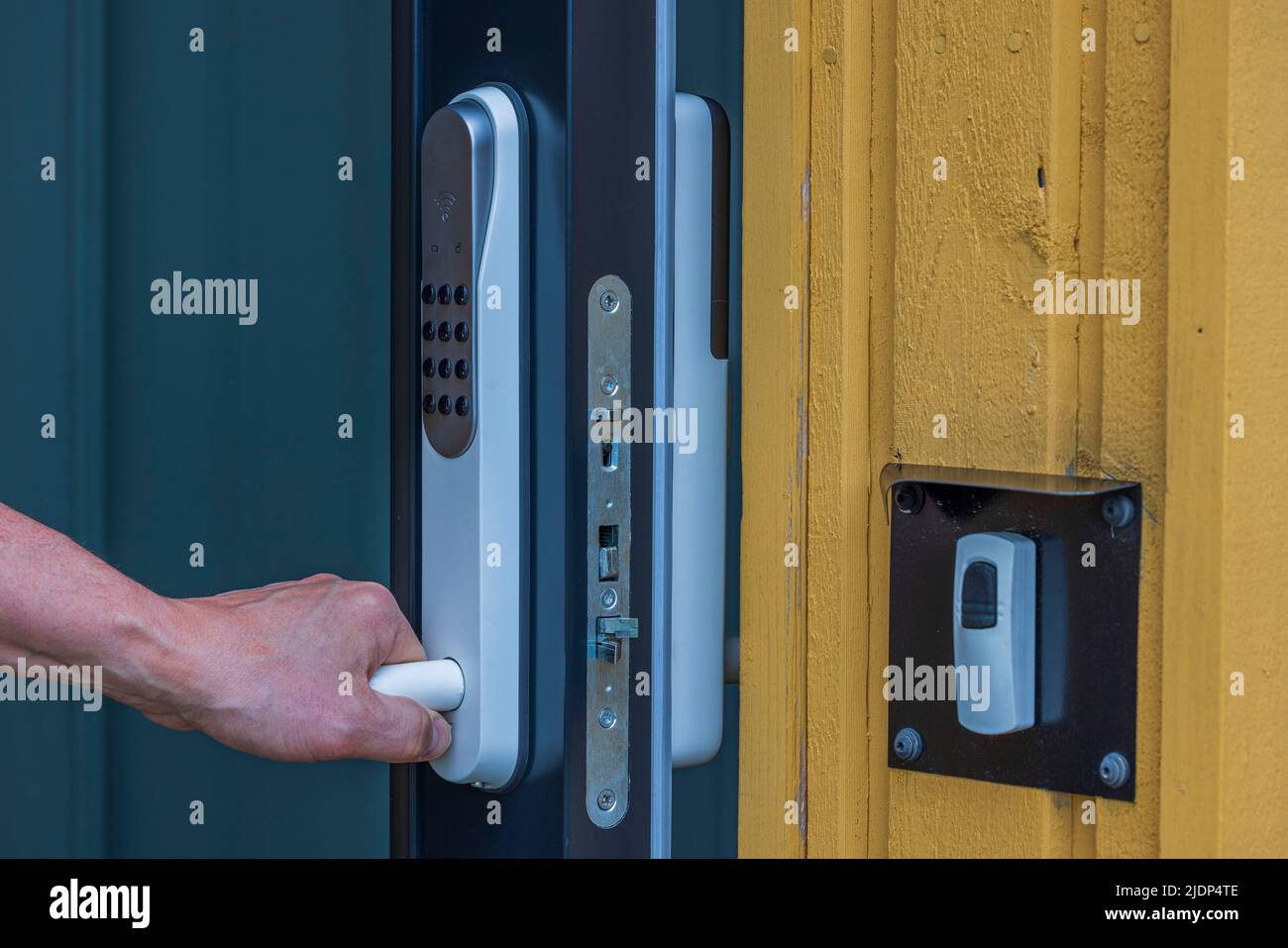 Close up view of man's hand opening entrance door with digital lock ...