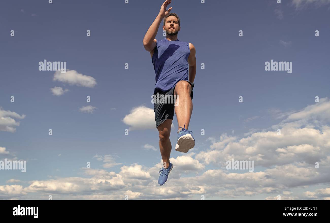 muscular man sprinter running in sportswear outdoor on sky background ...