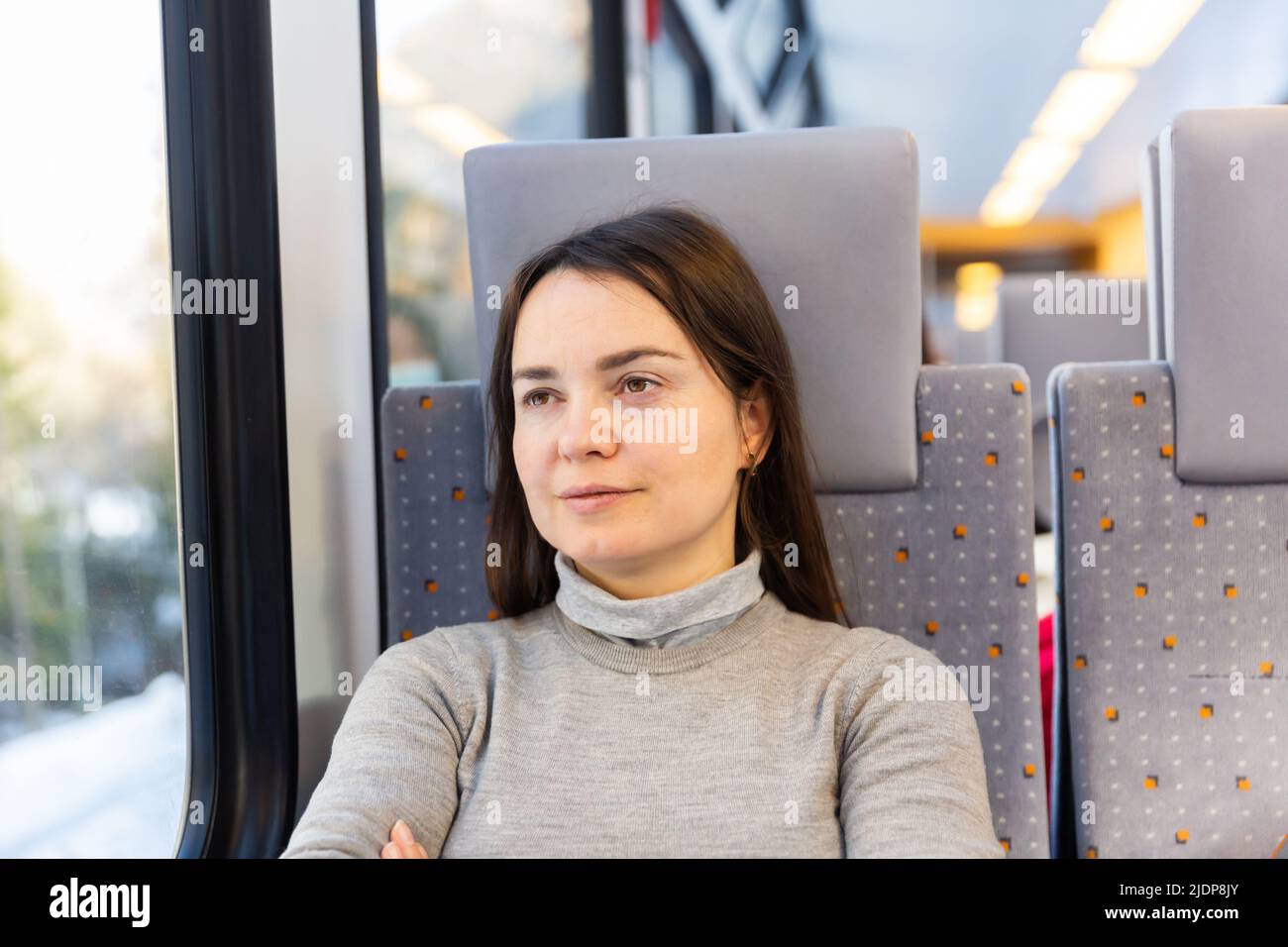 Portrait of woman sitting inside train Stock Photo - Alamy