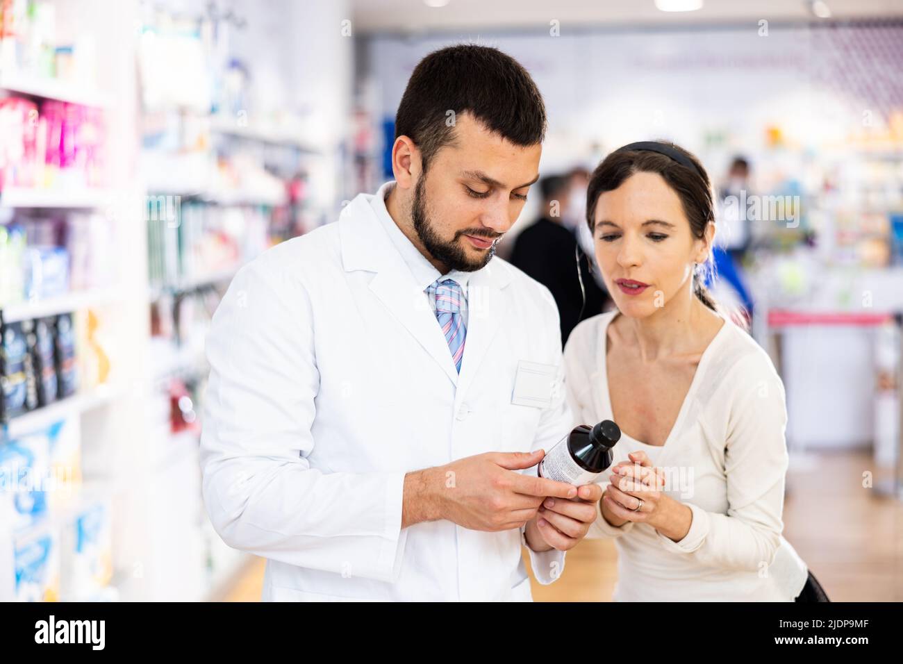 Pharmacist consulting woman buyer about drug Stock Photo - Alamy