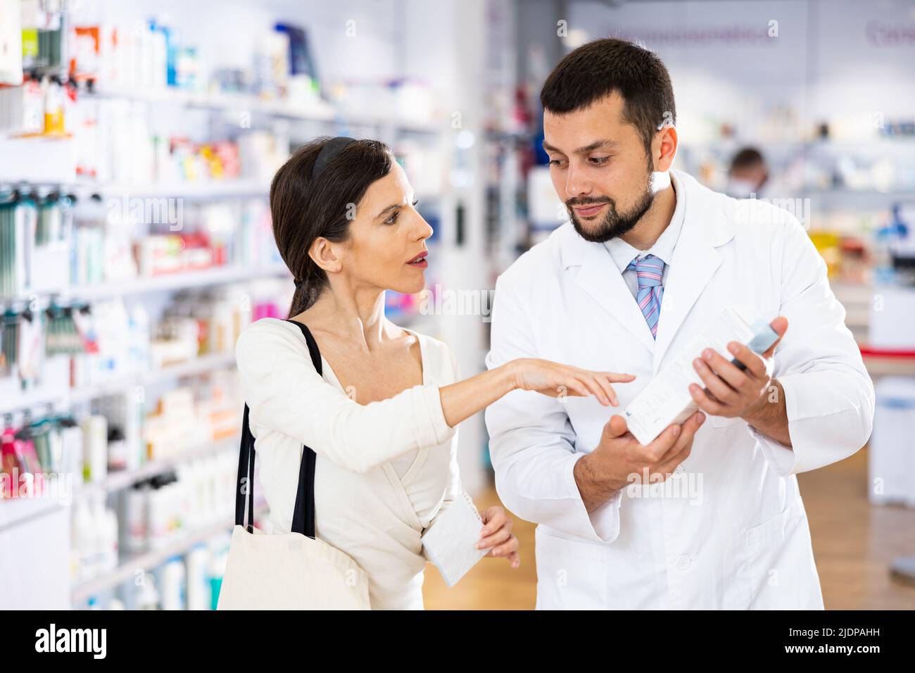 Female pharmacist offers medicine hi-res stock photography and images ...
