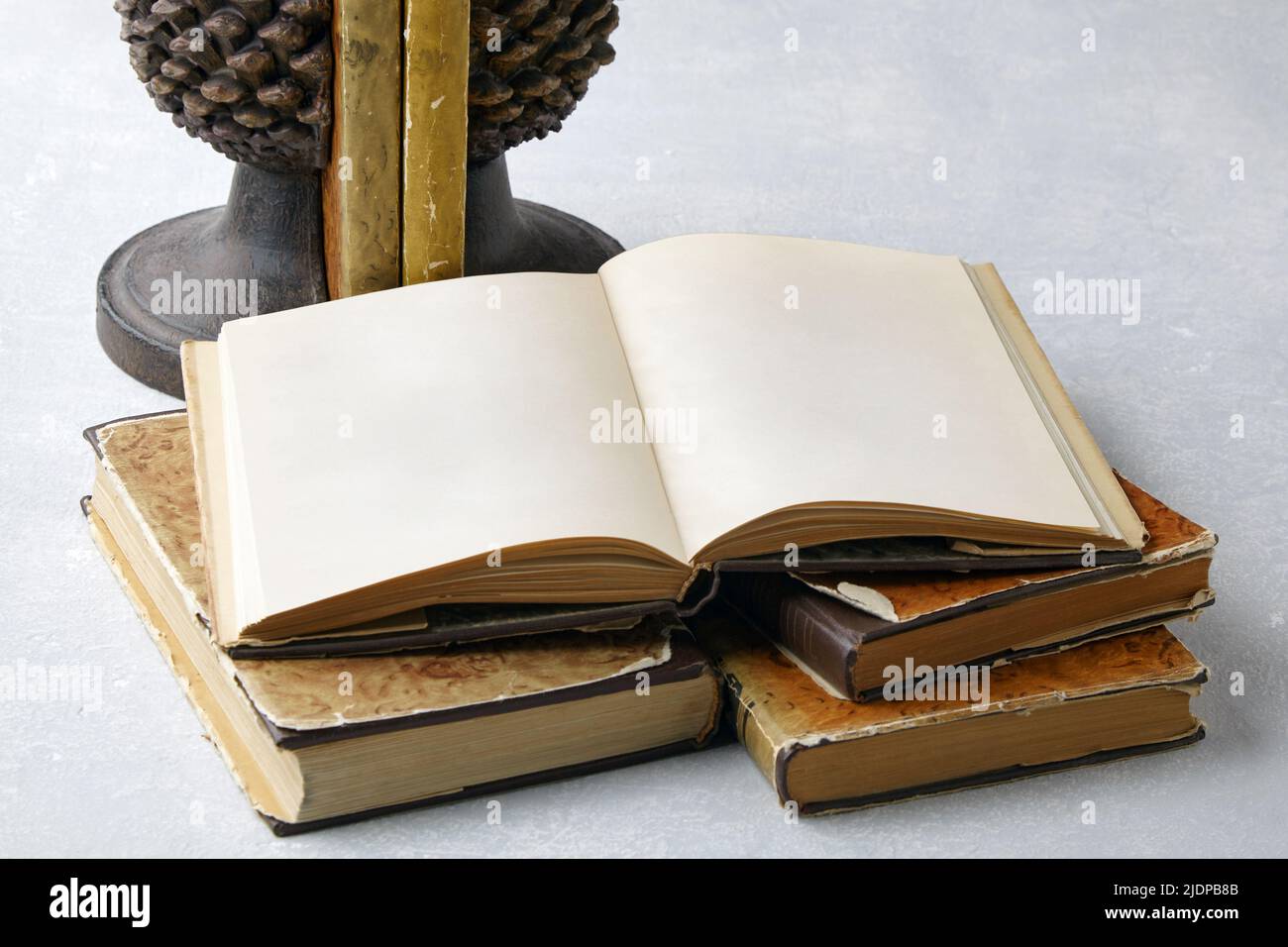 A shabby vintage book with blank pages on a stack of books on a white ...