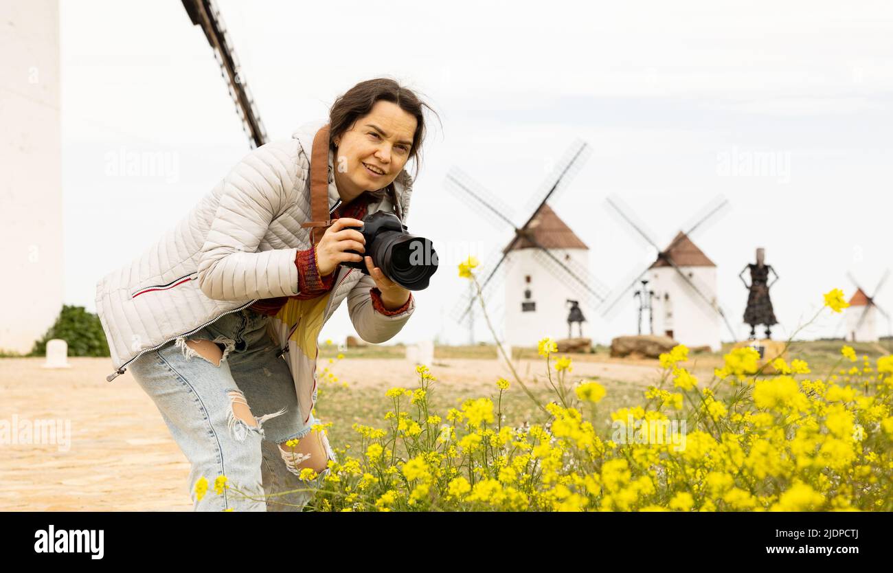 Woman tourist takes pictures of the windmills of Mota del cuervo. Spain ...