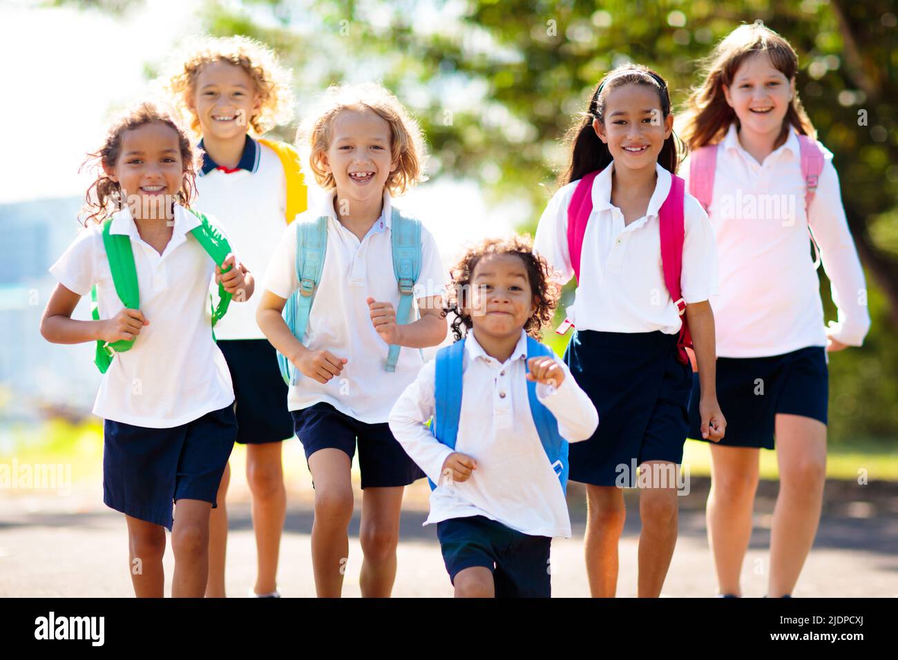 Kids go back to school. Interracial group of children of mixed age run ...