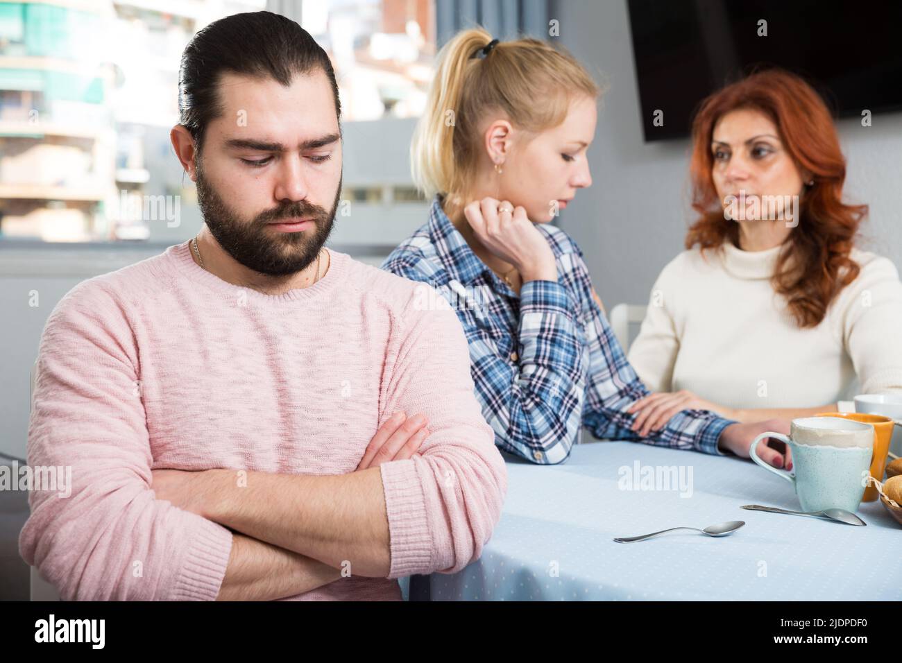 Angry wife and mother-in-law rebuking young man Stock Photo - Alamy
