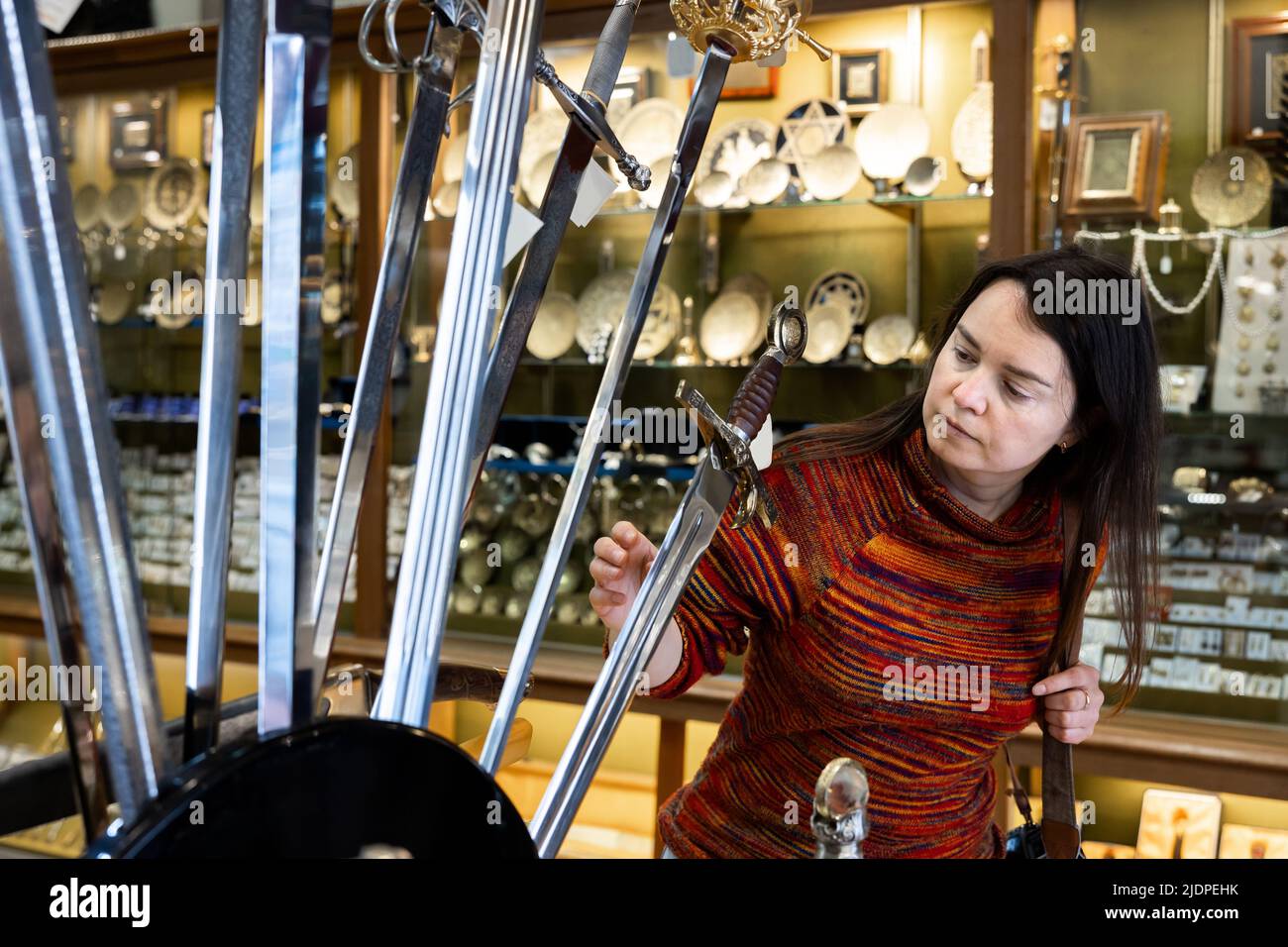 Woman tourist choosing handmade swords Stock Photo - Alamy