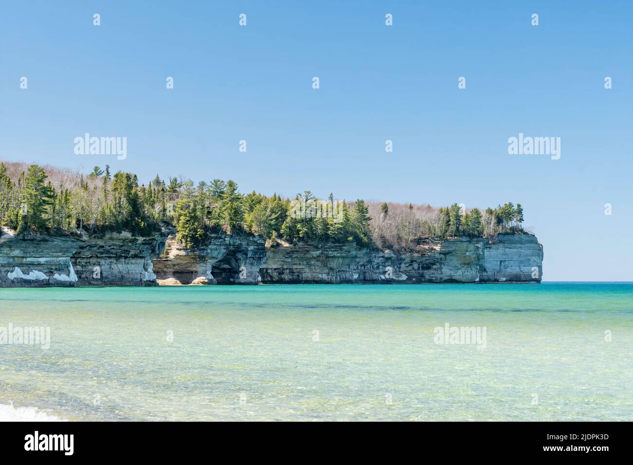 A tree lined shore of pictured rocks national shoreline in the Upper ...
