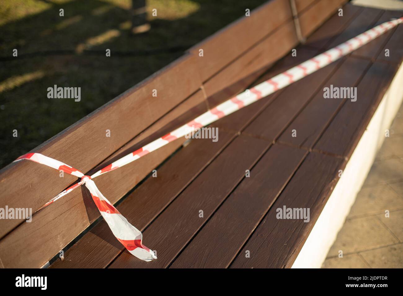 Painted shop in park. Red ribbon on wooden bench. Seat is closed for ...
