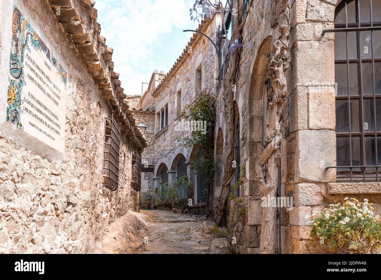 Narrow alley with old stone wall buildings in Spain. Facade of medieval ...