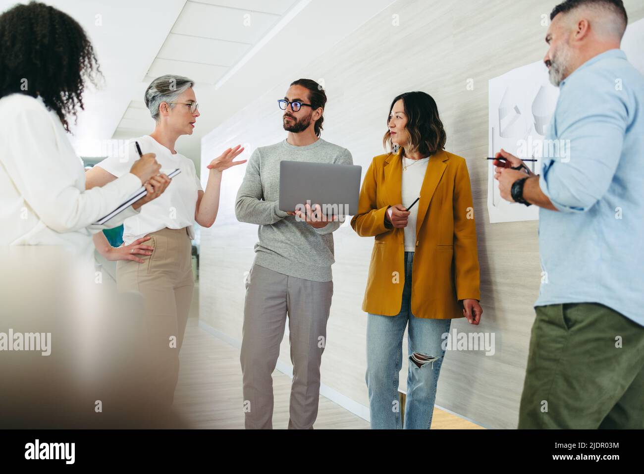 Multicultural design professionals sharing ideas during a meeting in a ...