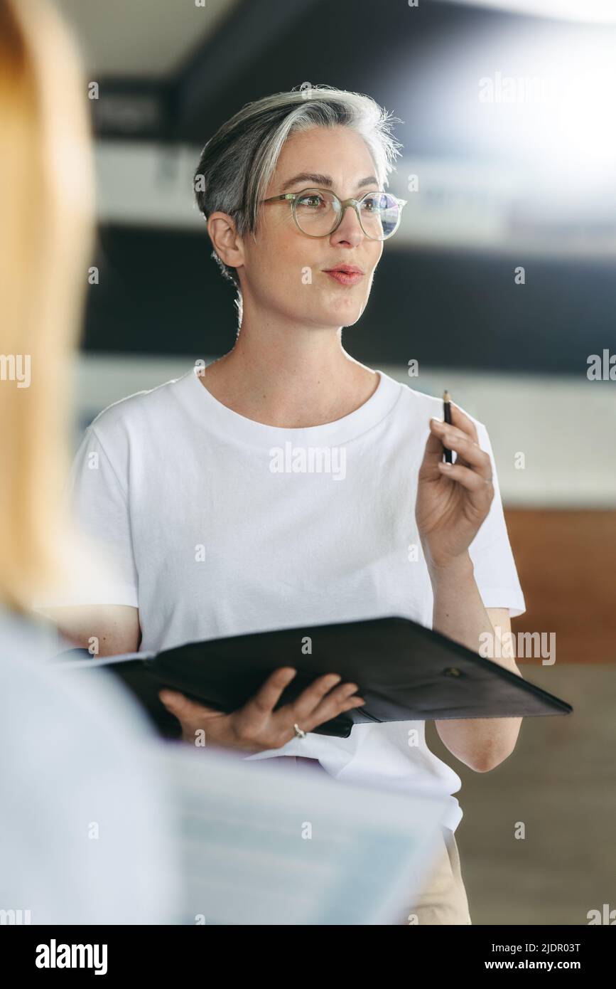 Female business manager having a meeting with her team in a modern ...