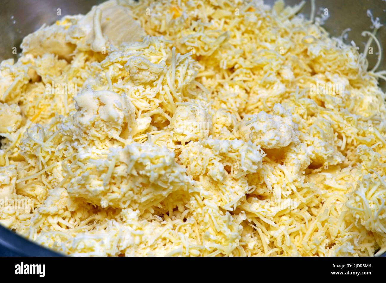 grated medium hard cheese in close up like cheddar, emental, gruyere ...