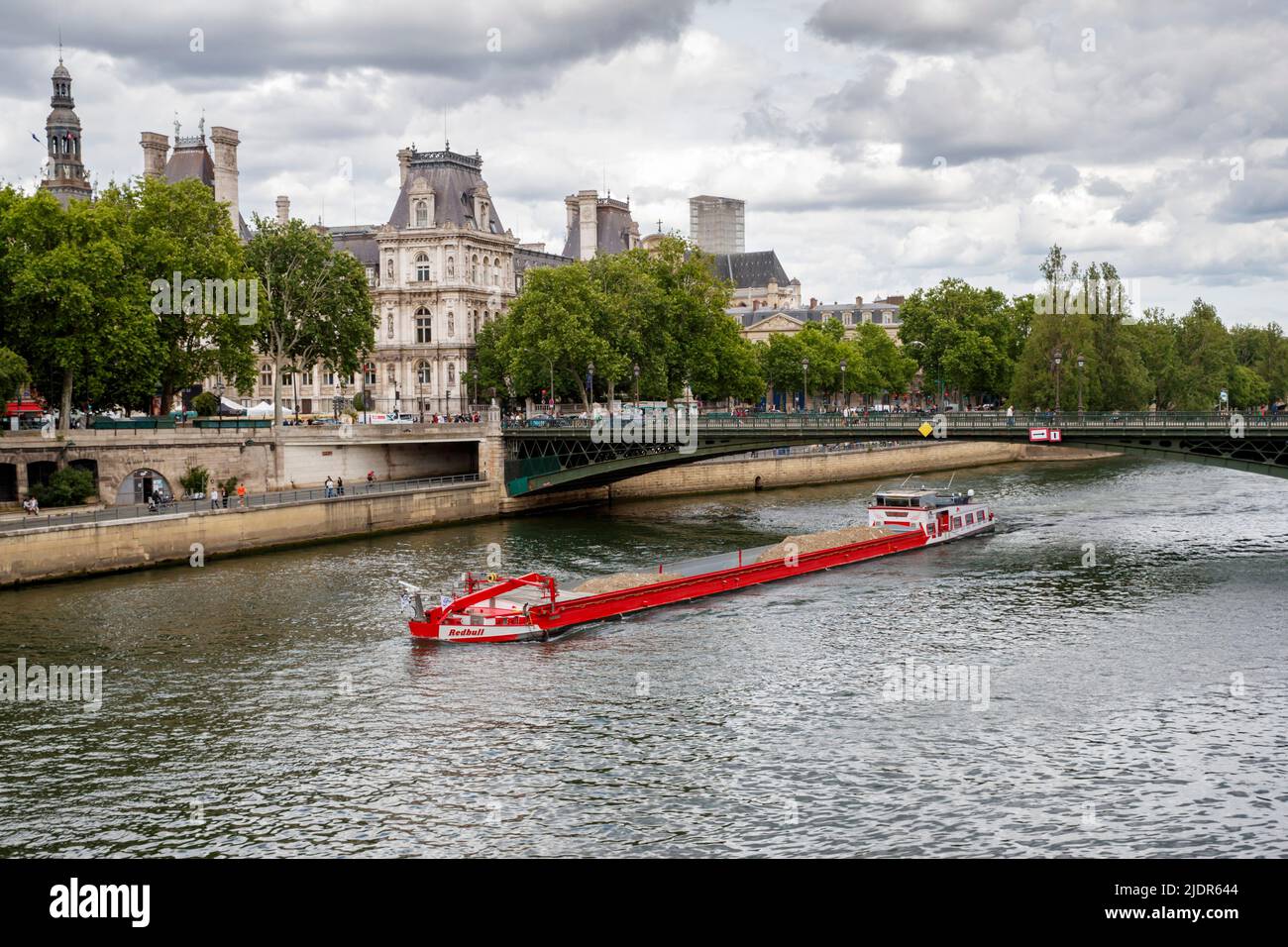 A barge on the River Seine with the town hall in background in Paris ...