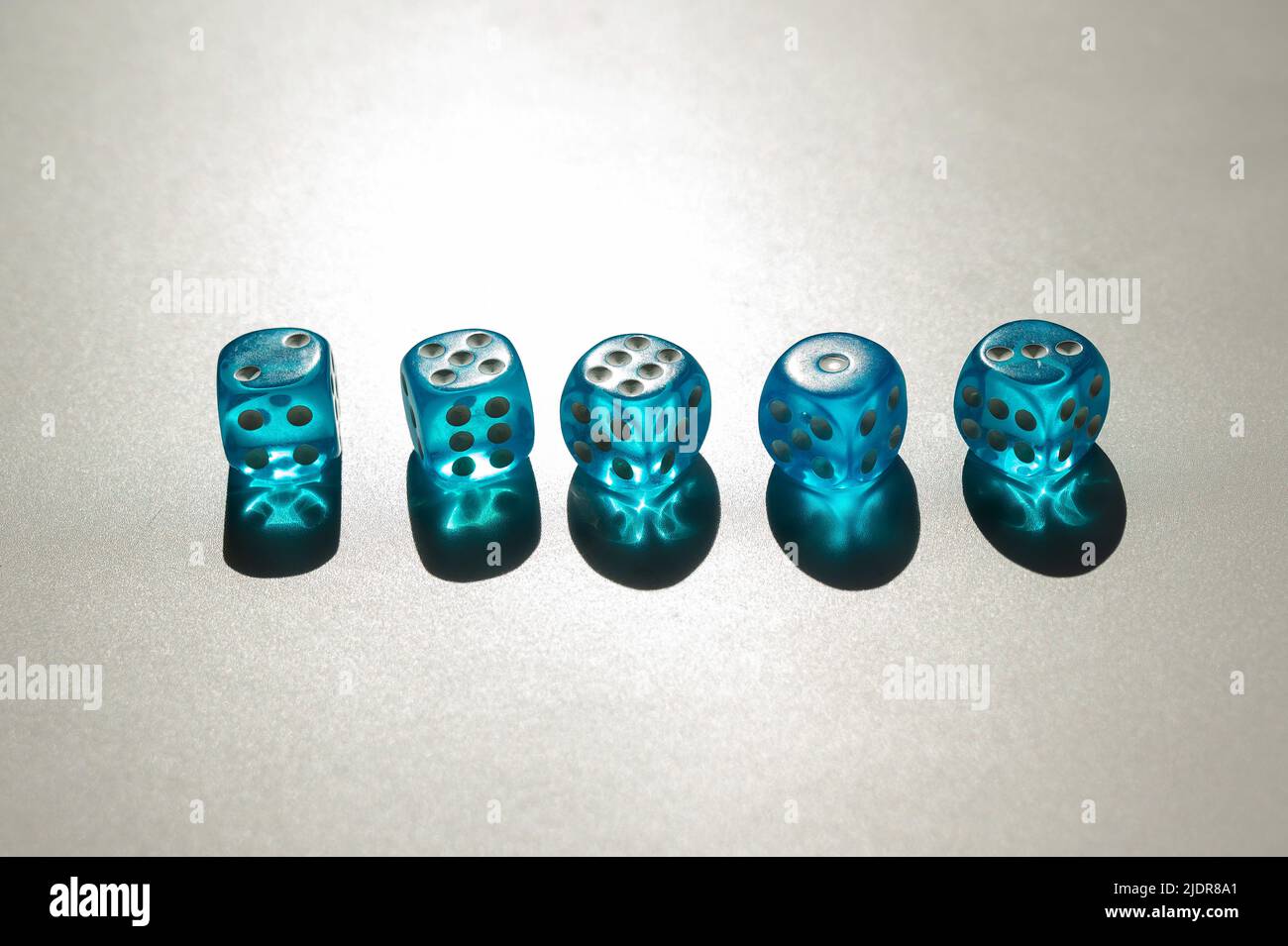 Five transparent blue dice on a white table Stock Photo - Alamy