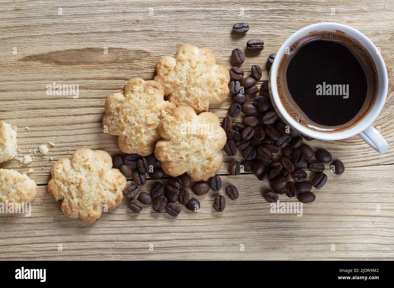Cup of coffee and shortbread with coconut chips on old wooden ...