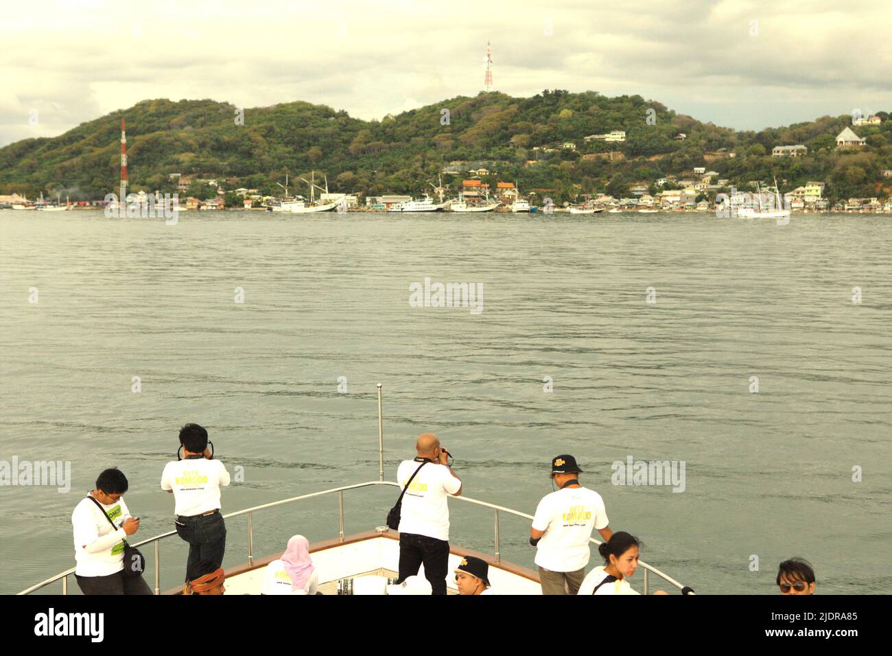 People standing on the bow of a boat that is heading to the coastal ...