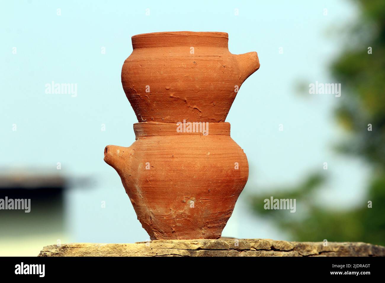 red color clay pot put on a stone Stock Photo - Alamy