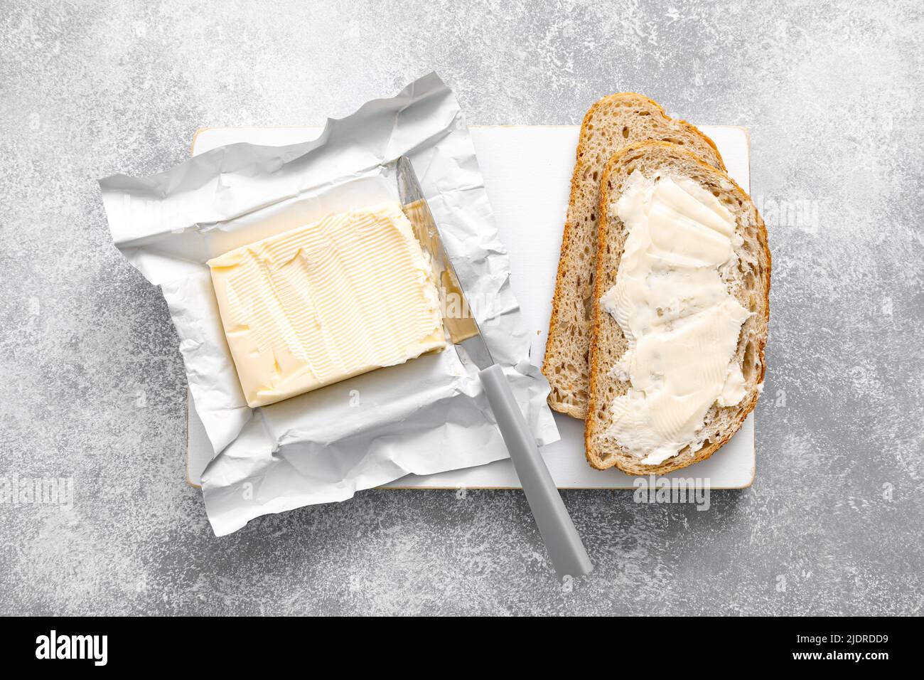 Block of butter with butter knife in a open pack. Buttering bread Stock ...