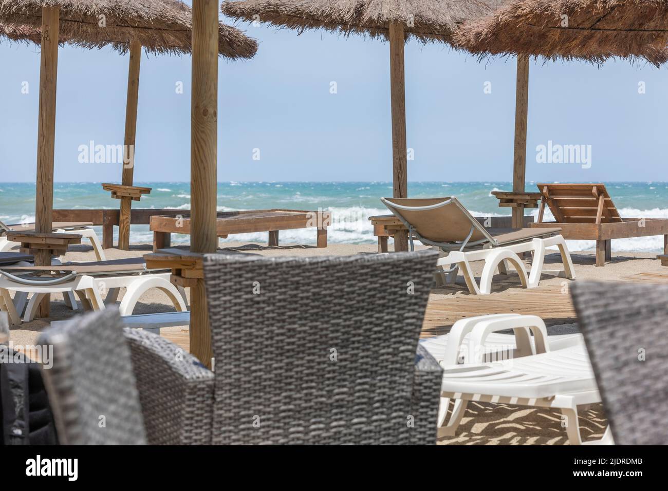 Tables, chairs and palm umbrellas in a mediterranean beach bar Stock ...