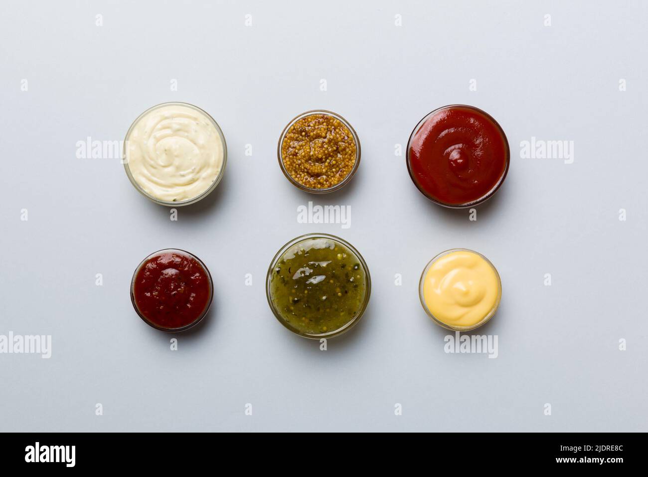 Different types of sauces in bowls on a colored Board . Top view ...
