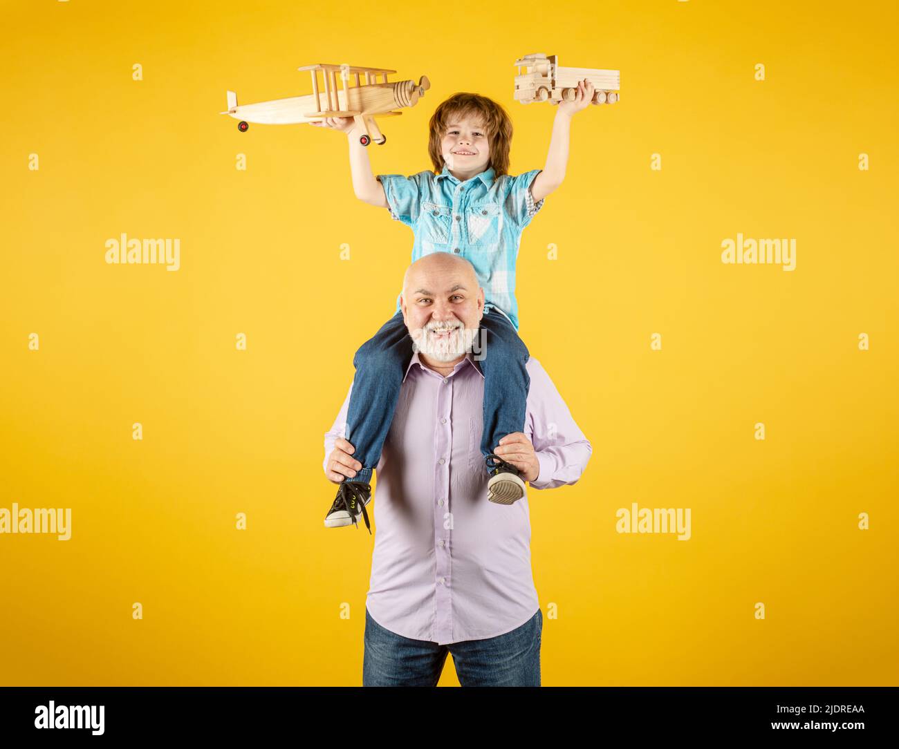 Child boy and grandfather playing piggyback ride with plane and wooden ...