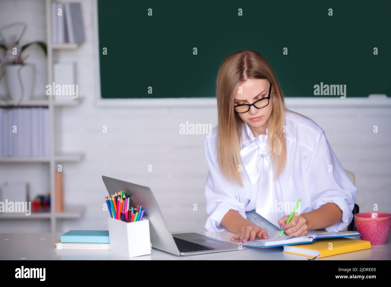 Female college student preparing for test or exam, writing, using ...