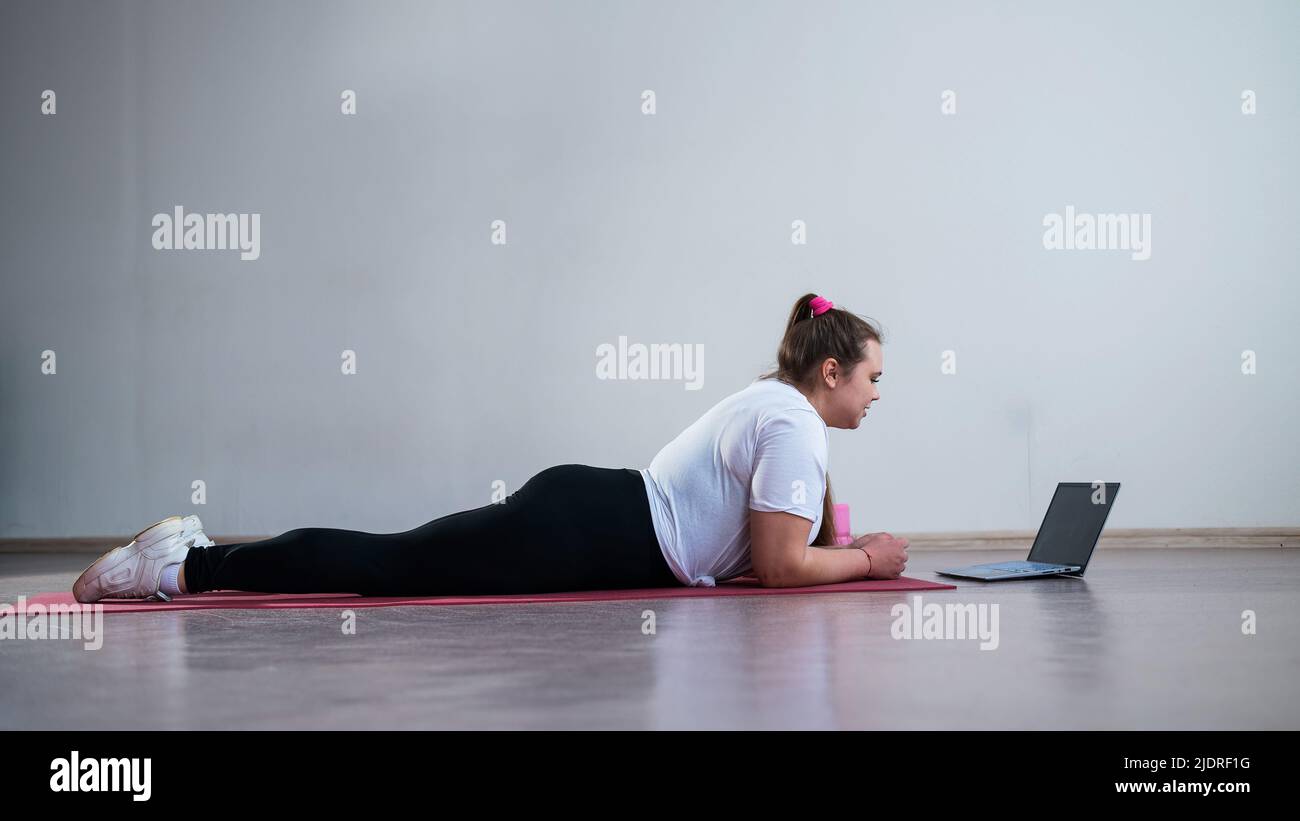 Young Plus Size Woman Stretching At Home Online. Flexible girl ...