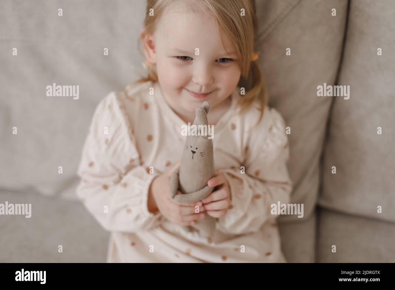 Little girl holding a toy at home. Happy child Stock Photo - Alamy
