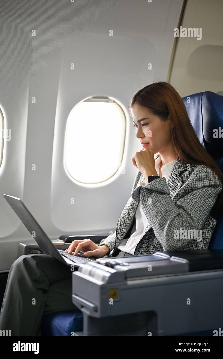 Professional asian businesswoman on a plane going to aboard meeting ...
